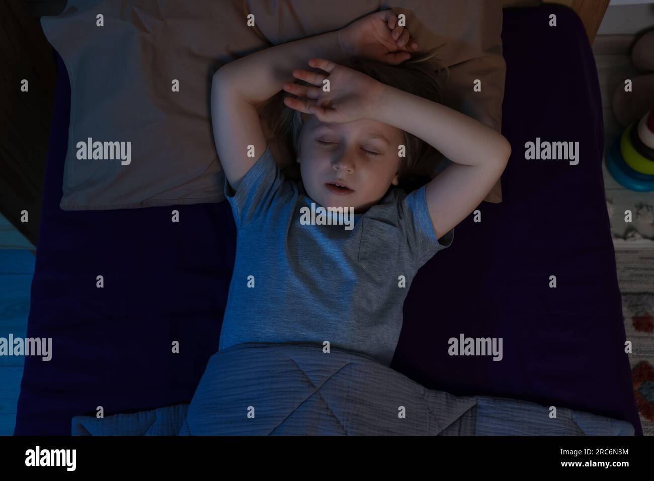 Little boy snoring while sleeping in bed at night, top view Stock Photo ...