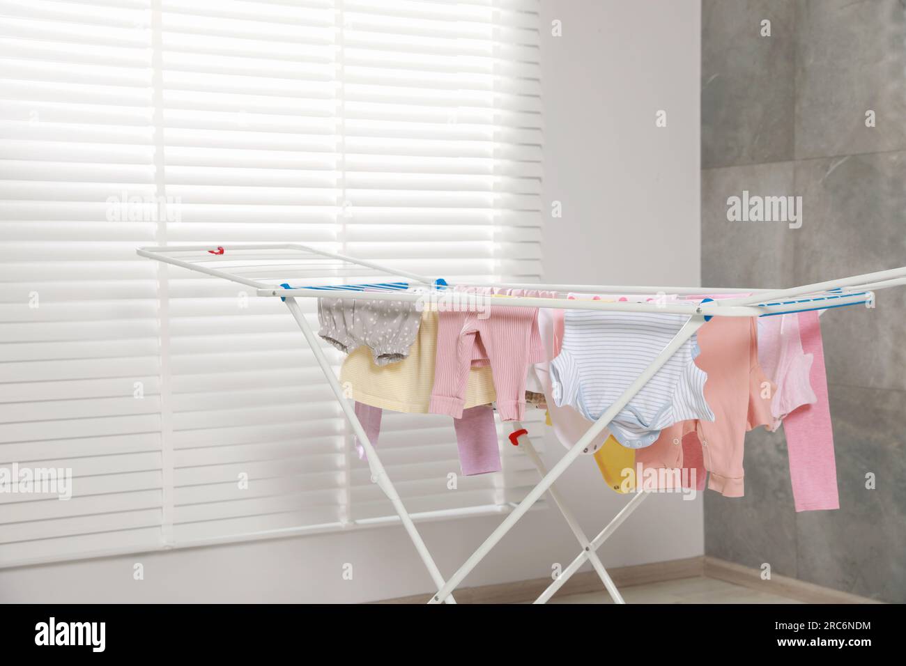 Clean laundry hanging on drying rack indoors Stock Photo - Alamy