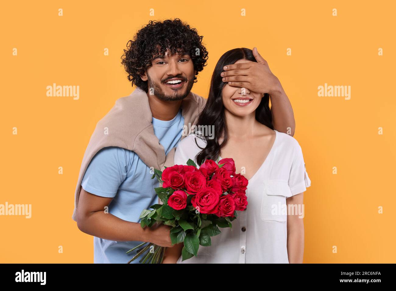 International dating. Handsome man presenting roses to his beloved ...