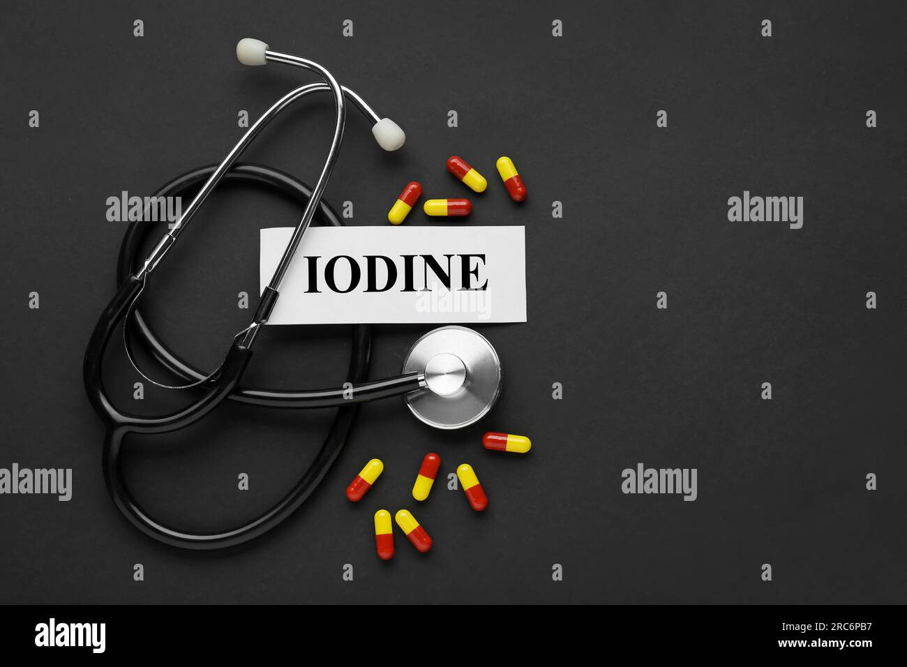 Card with word Iodine, stethoscope and pills on black background, flat ...