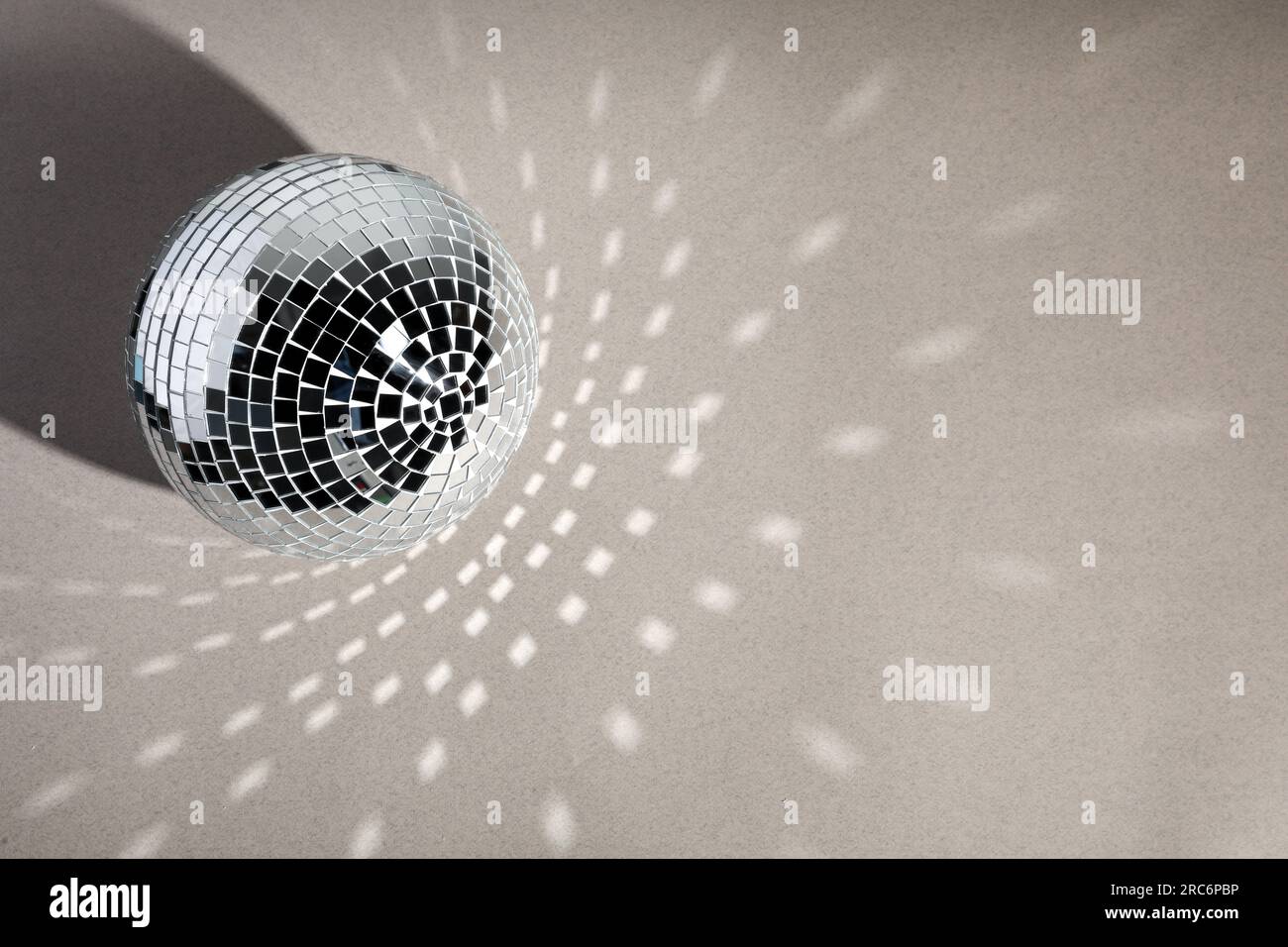 Shiny disco ball on light grey background, top view. Space for text ...