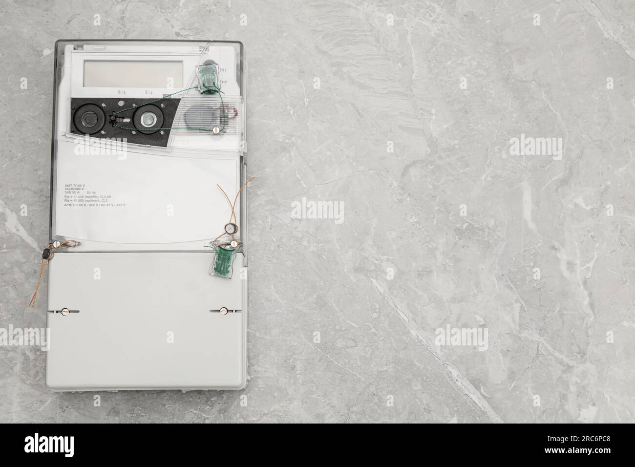 Electric meter on light grey marble background, top view with space for ...