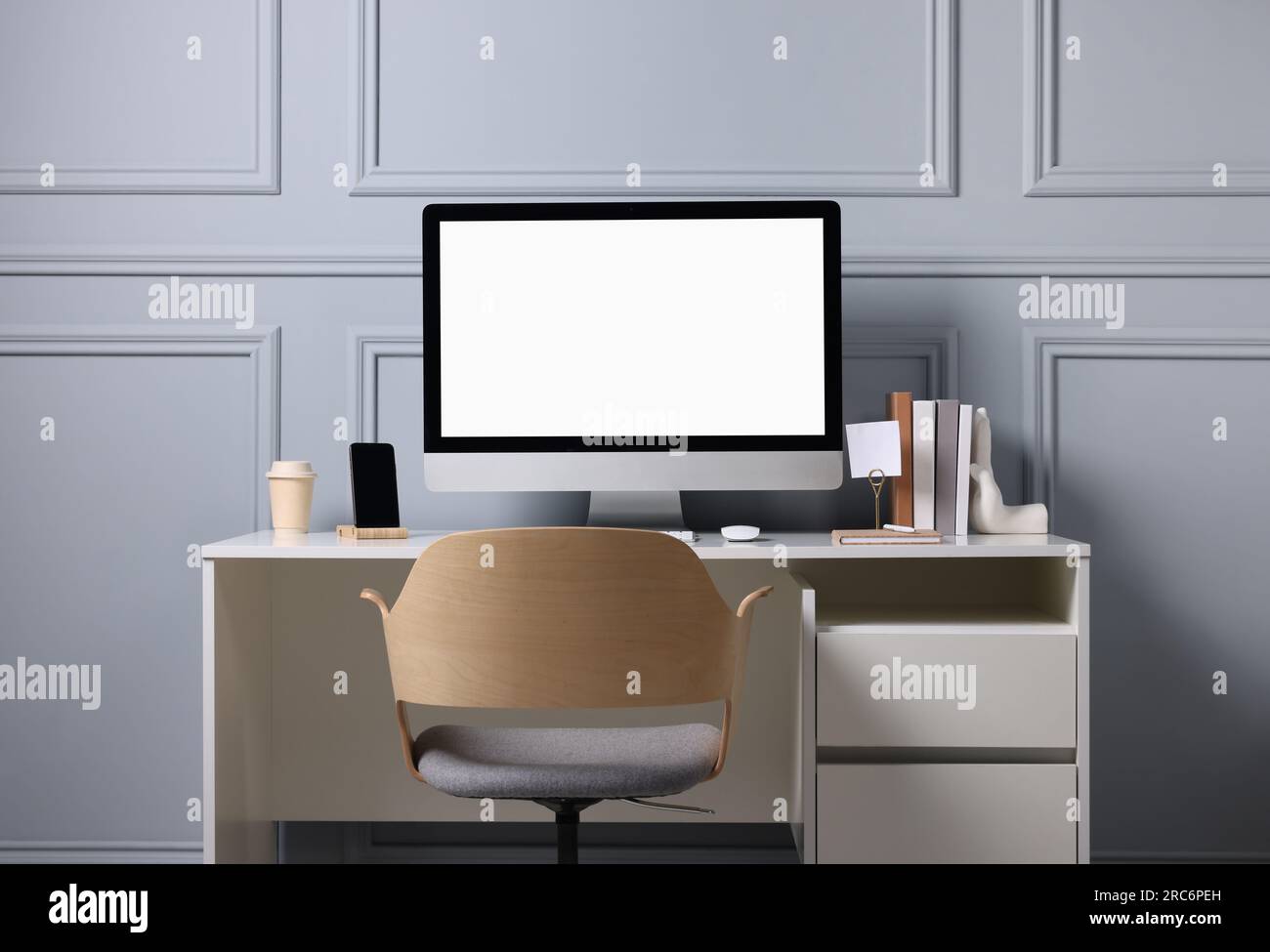 Cozy workspace with comfortable chair and computer on white desk ...