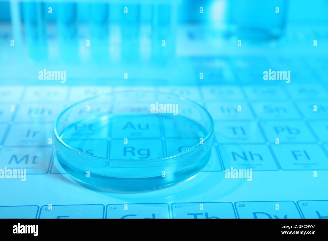 Petri dish on periodic table of elements, closeup. Color tone effect ...