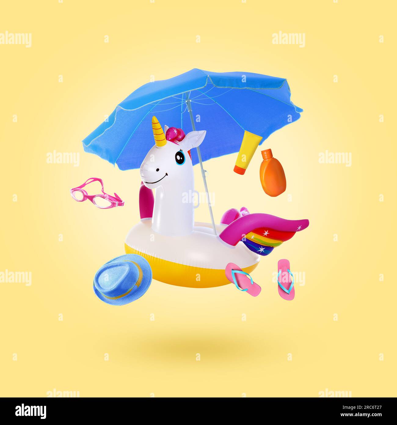 Sunscreen and beach accessories flying on pale yellow background Stock ...