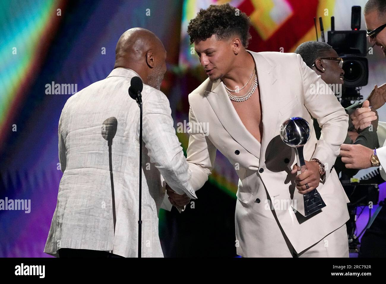 Former professional boxer Mike Tyson, left, presents the best team award to NFL football player ...