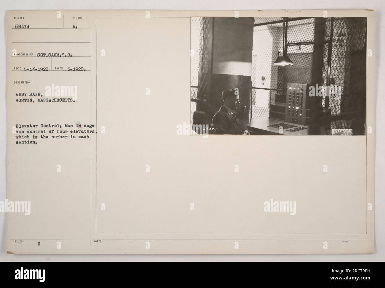 Man in an elevator control cage overseeing four elevators at an Army ...