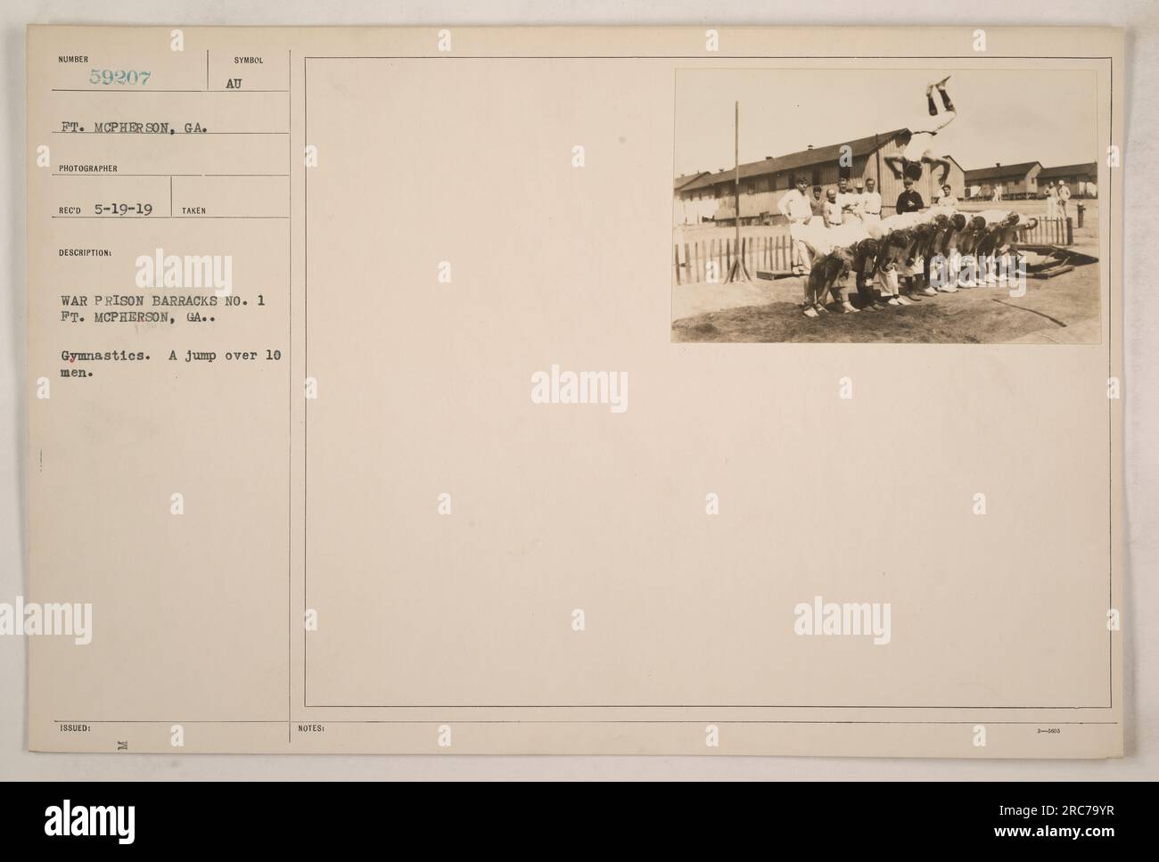 Soldier performing a gymnastic jump over ten men at War Prison Barracks ...