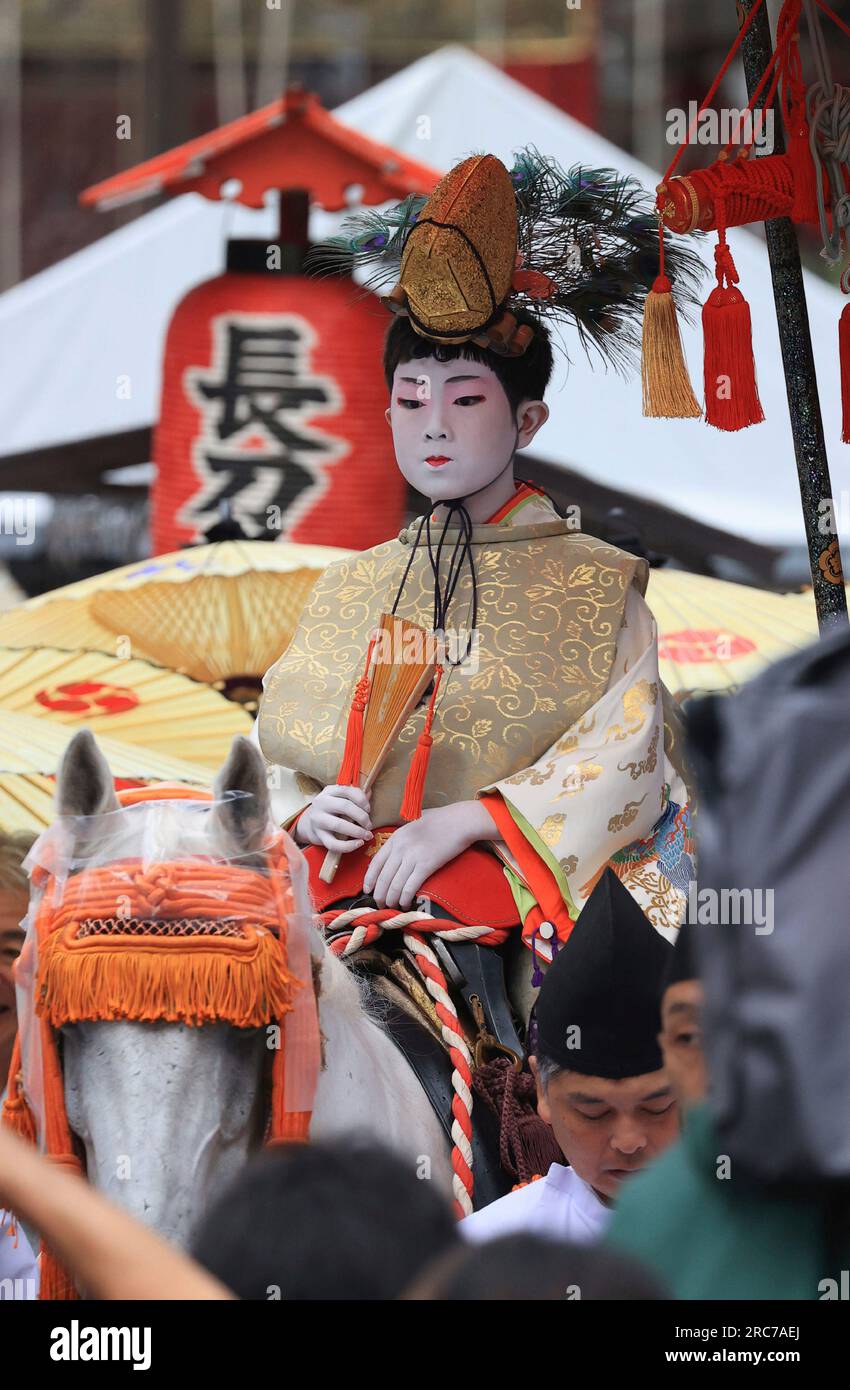 A festival-chosen child, "chigo," rides on a white horse toward Yasaka ...