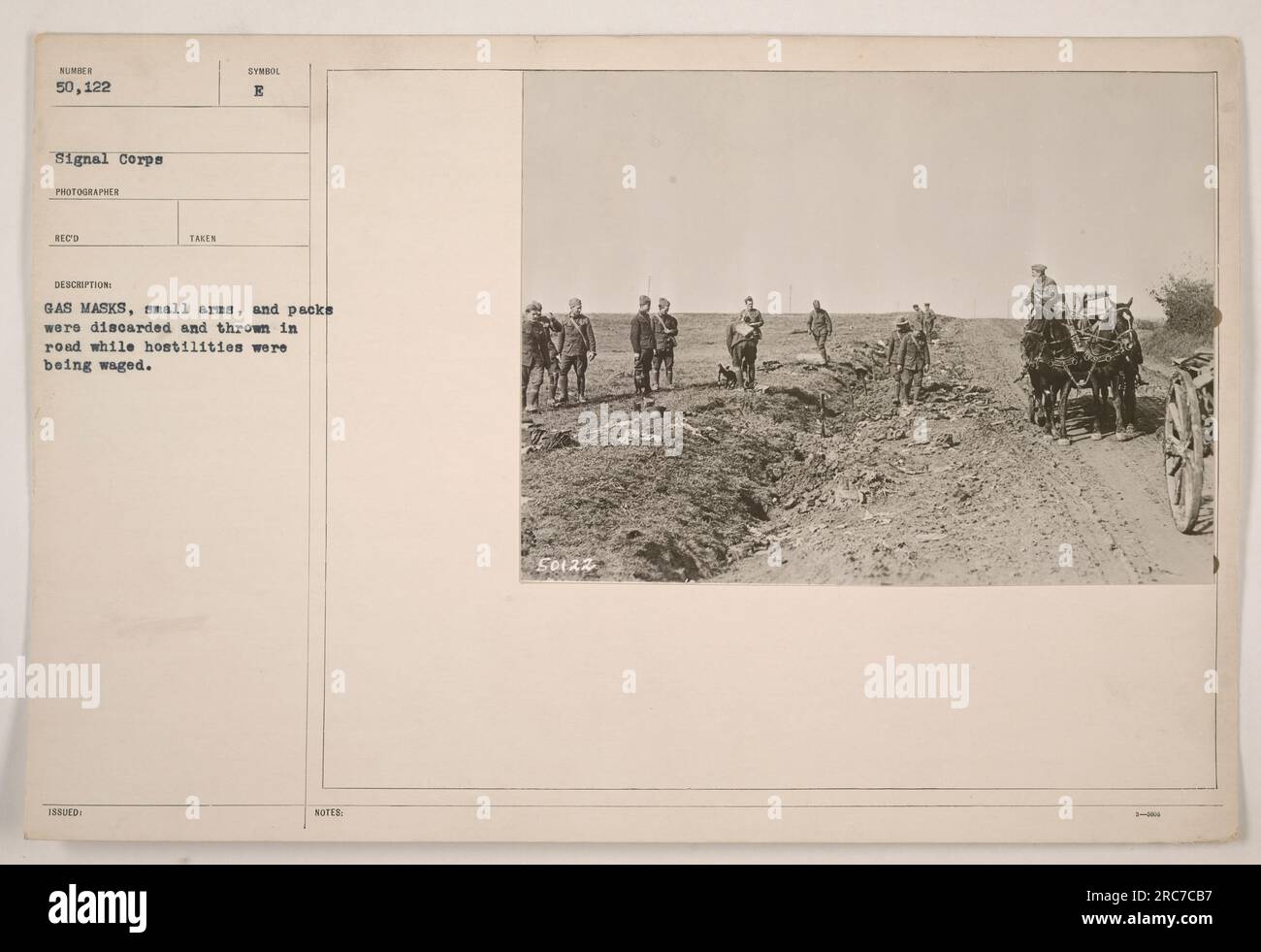 Soldiers discarding gas masks, small arms, and packs on the road during ...