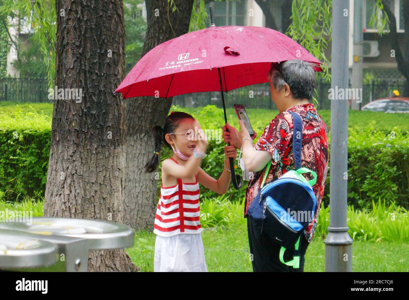 BEIJING, CHINA - JULY 13, 2023 - People travel in the rain in Beijing ...
