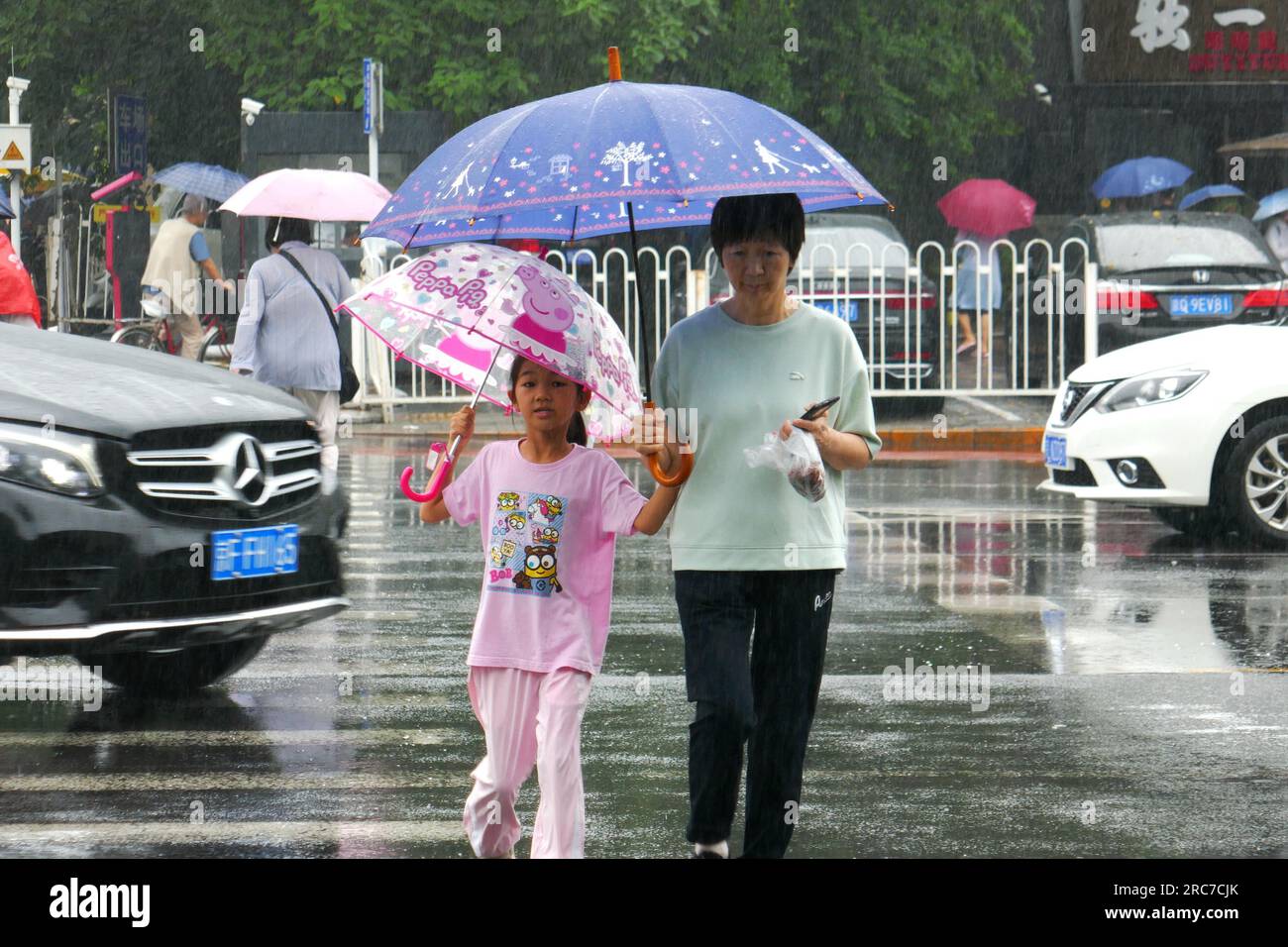 BEIJING, CHINA - JULY 13, 2023 - People travel in the rain in Beijing ...