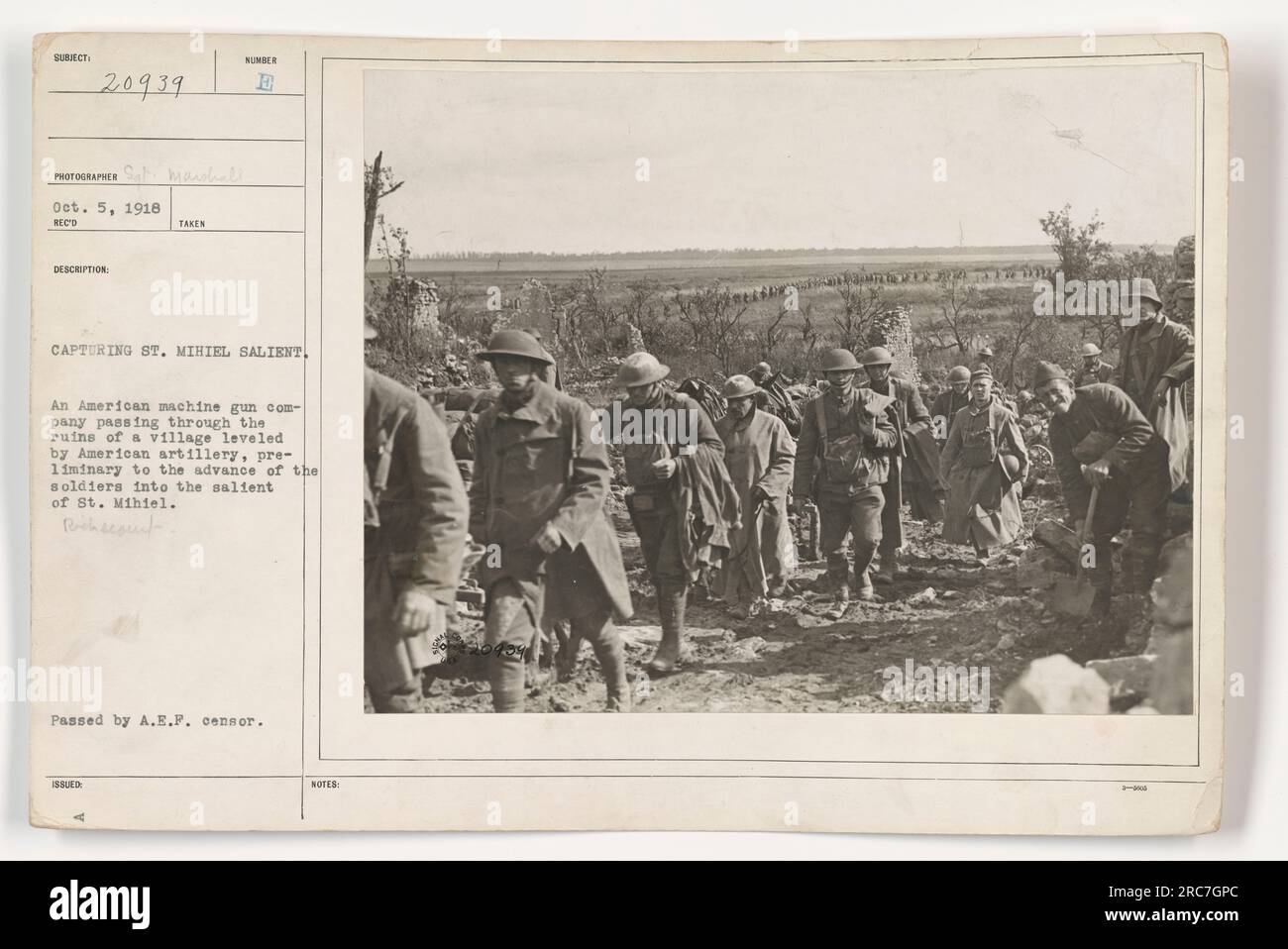 Caption: "American machine gun company passes through a village destroyed by American artillery ...