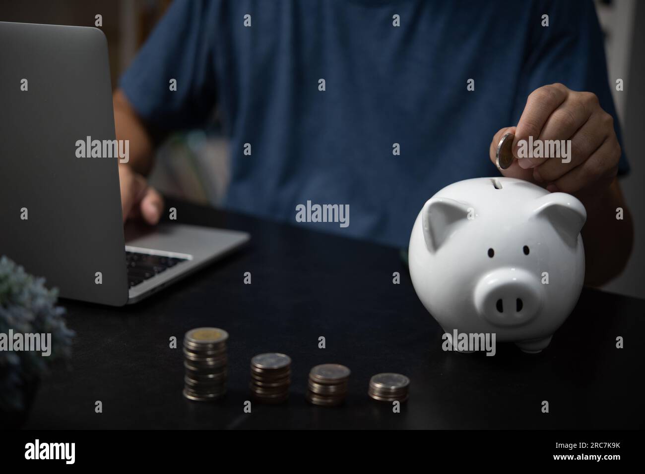 man holding coins and piggy bank with laptop computer. Business finance ...