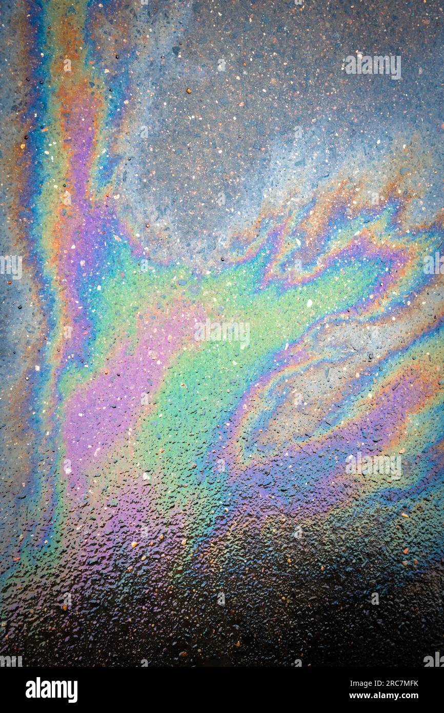 Oil stain on the asphalt, rainbow-shaped colored gasoline stains on an ...