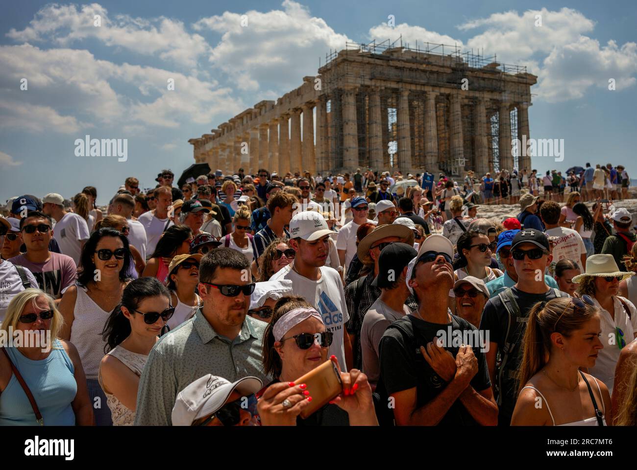 Atop the Acropolis ancient hill, tourists visit the Parthenon temple ...