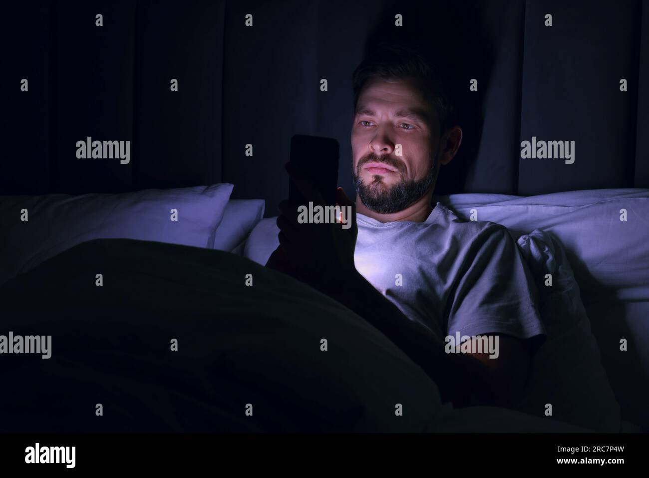 Man using smartphone in bed at night. Internet addiction Stock Photo ...