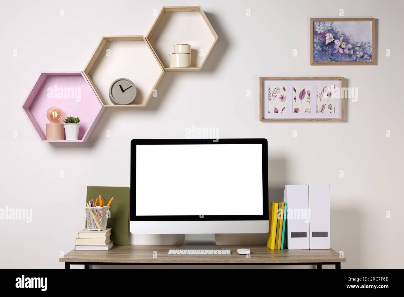 Computer on wooden desk and shelves indoors. Cozy workspace Stock Photo ...