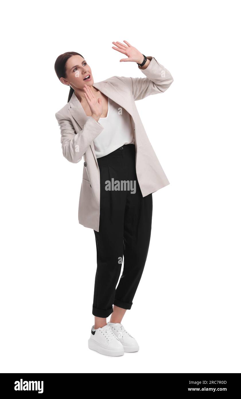 Beautiful businesswoman in suit avoiding something on white background ...