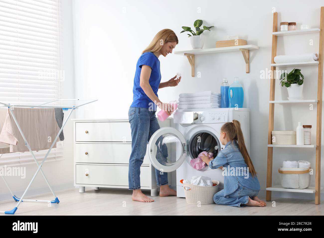 Child putting clothes washing machine hi-res stock photography and ...