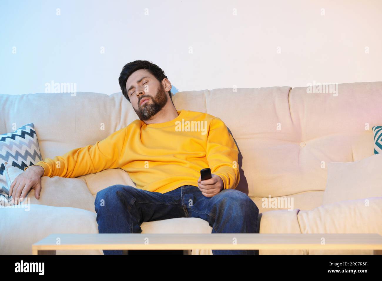Man sleeping while watching TV on sofa Stock Photo - Alamy