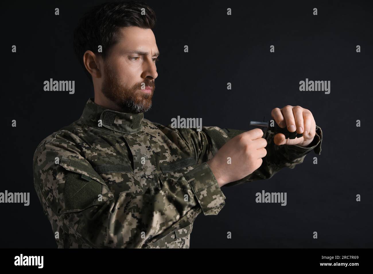 Soldier pulling safety pin out of hand grenade on black background ...
