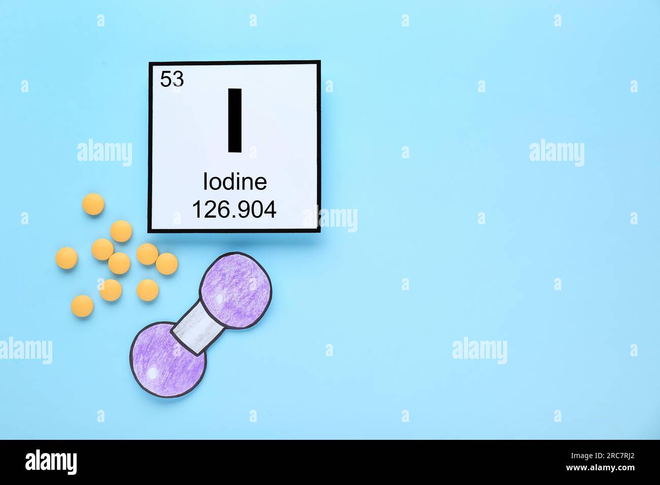 Card with iodine element, atom made of paper and pills on light blue ...