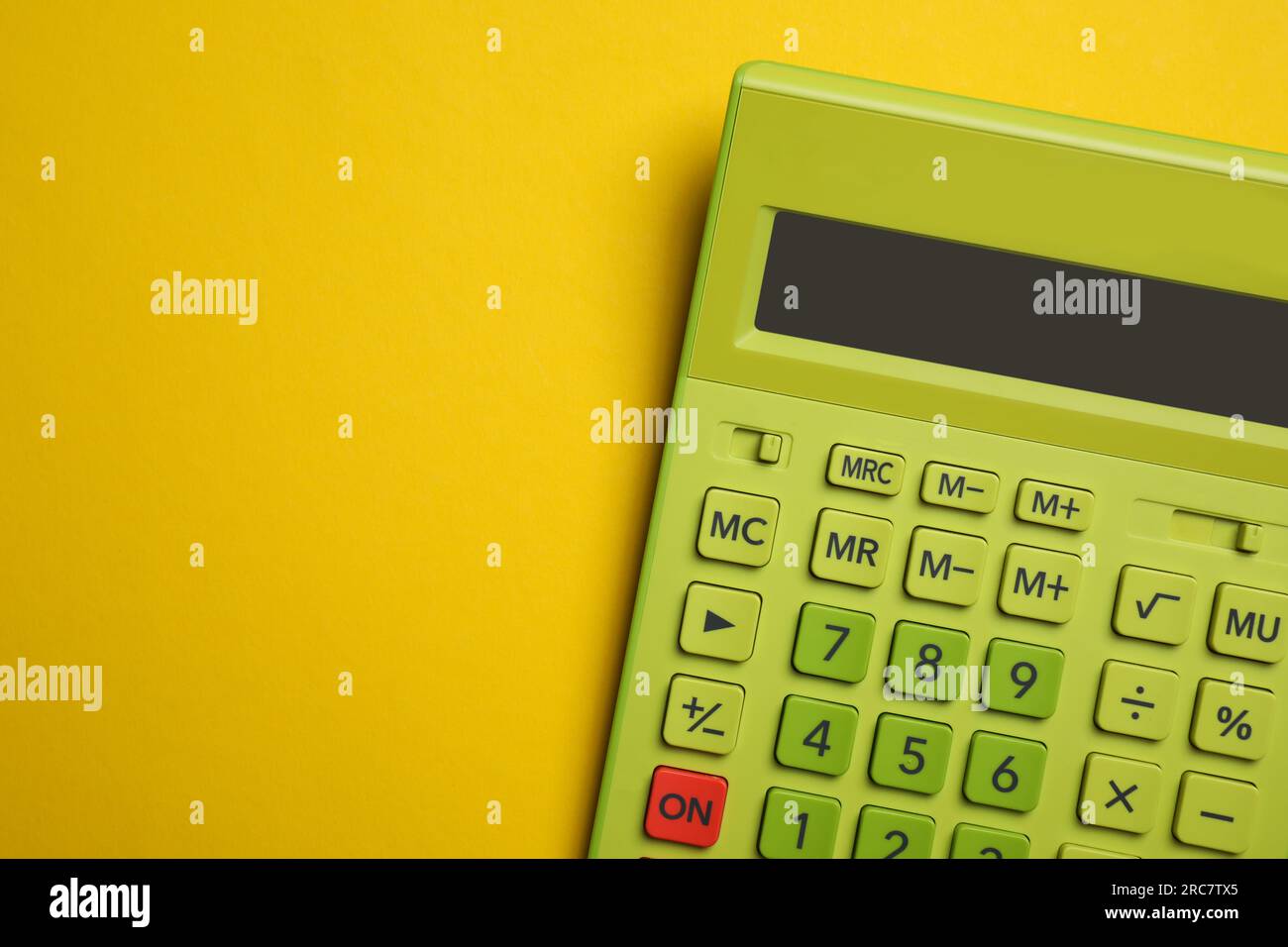 Green calculator on yellow background, top view with space for text ...