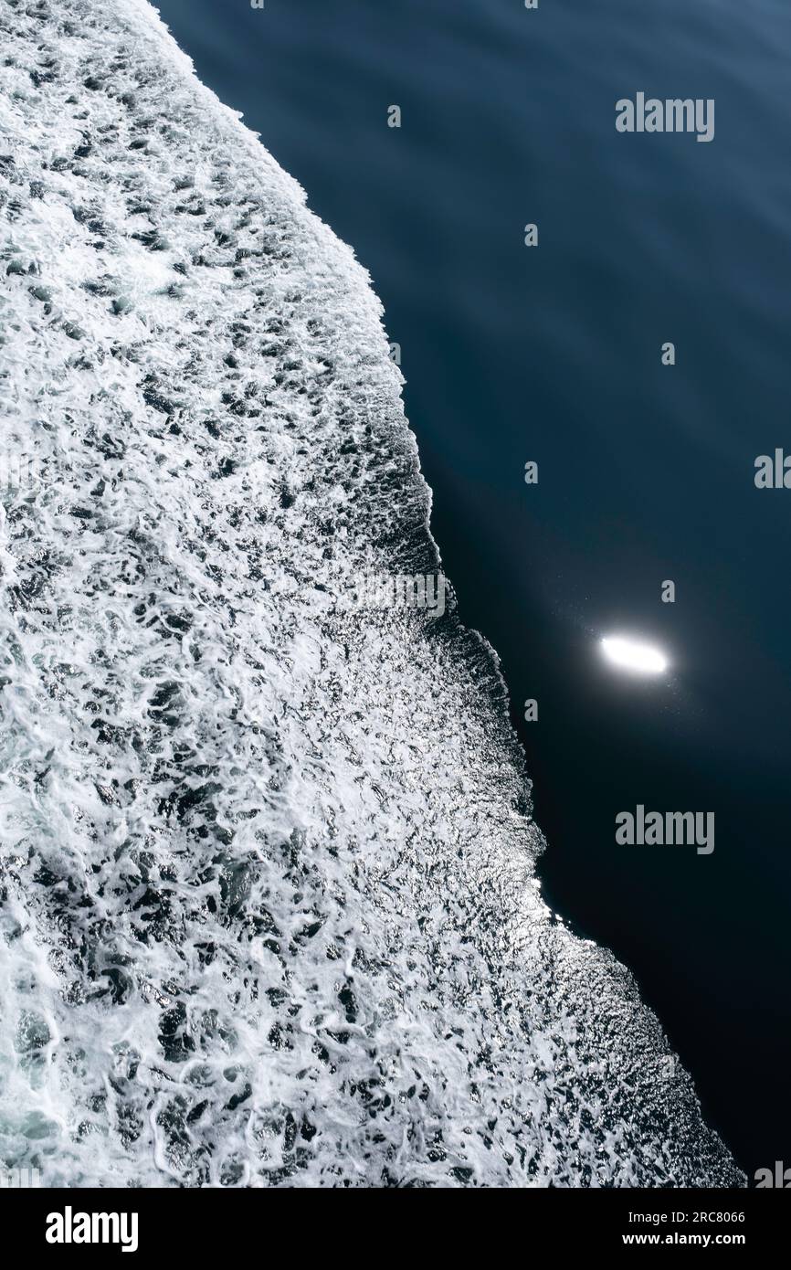 Bow waves of a ship with foam on the water of the sea. Splashing water ...