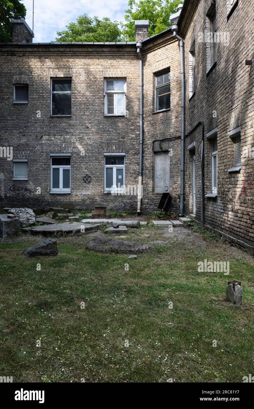 Courtyard overgrown with grass with old dilapidated brick houses in ...