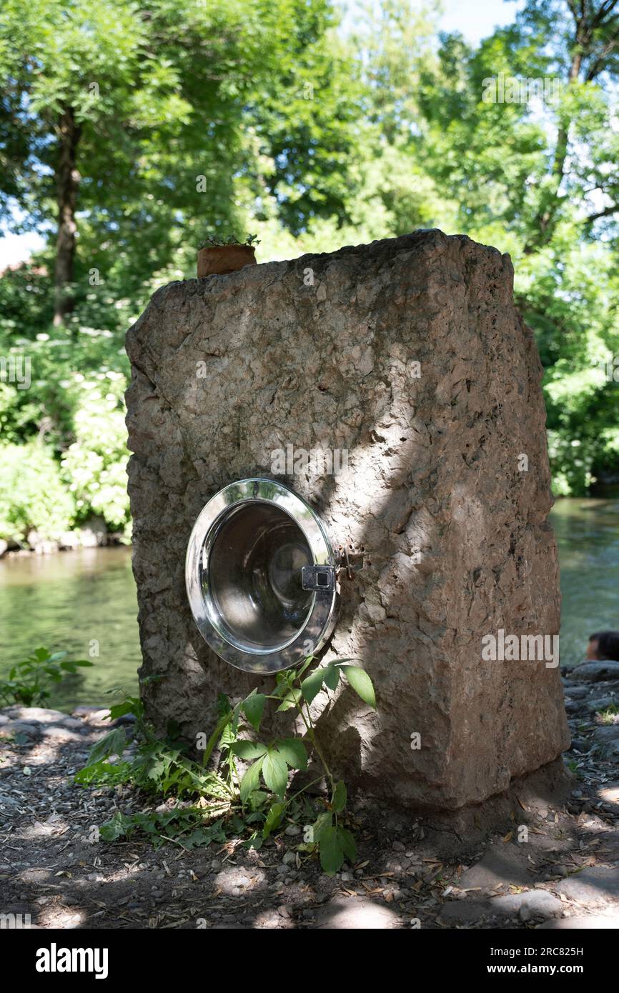 Large rectangular rock with a glass lid on the side, depicting a ...