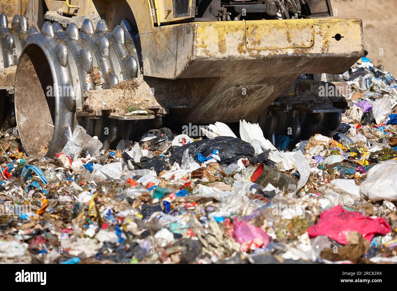 Heavy machinery shredding garbage in an open air landfill. Waste Stock ...