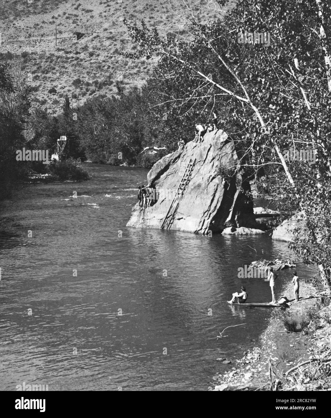 United States: 1910 Boys diving off a huge rock at the swimming hole in ...