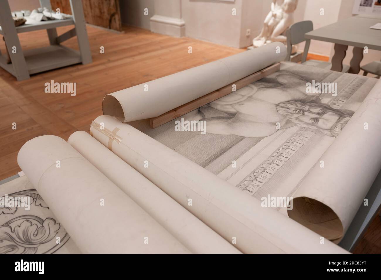 Old rolls of paper with images of buildings and statues for restoration ...