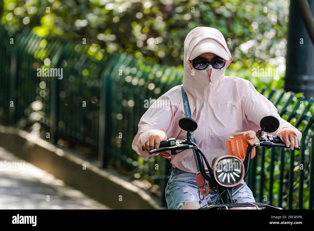 People go out wearing sun protective clothing amid high temperature in ...