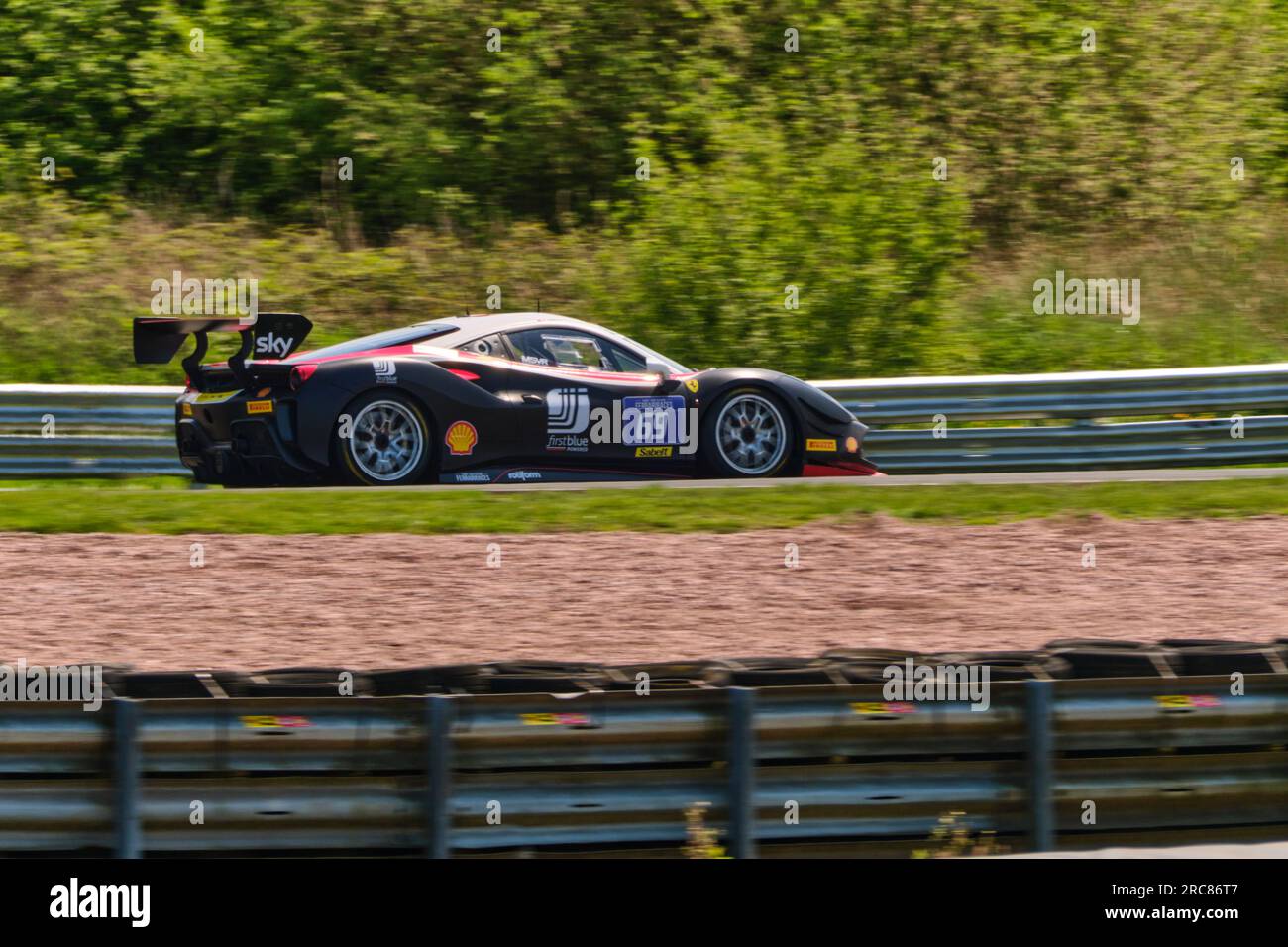 A black Ferrari Challenge race car during qualifying on a damp Oulton ...