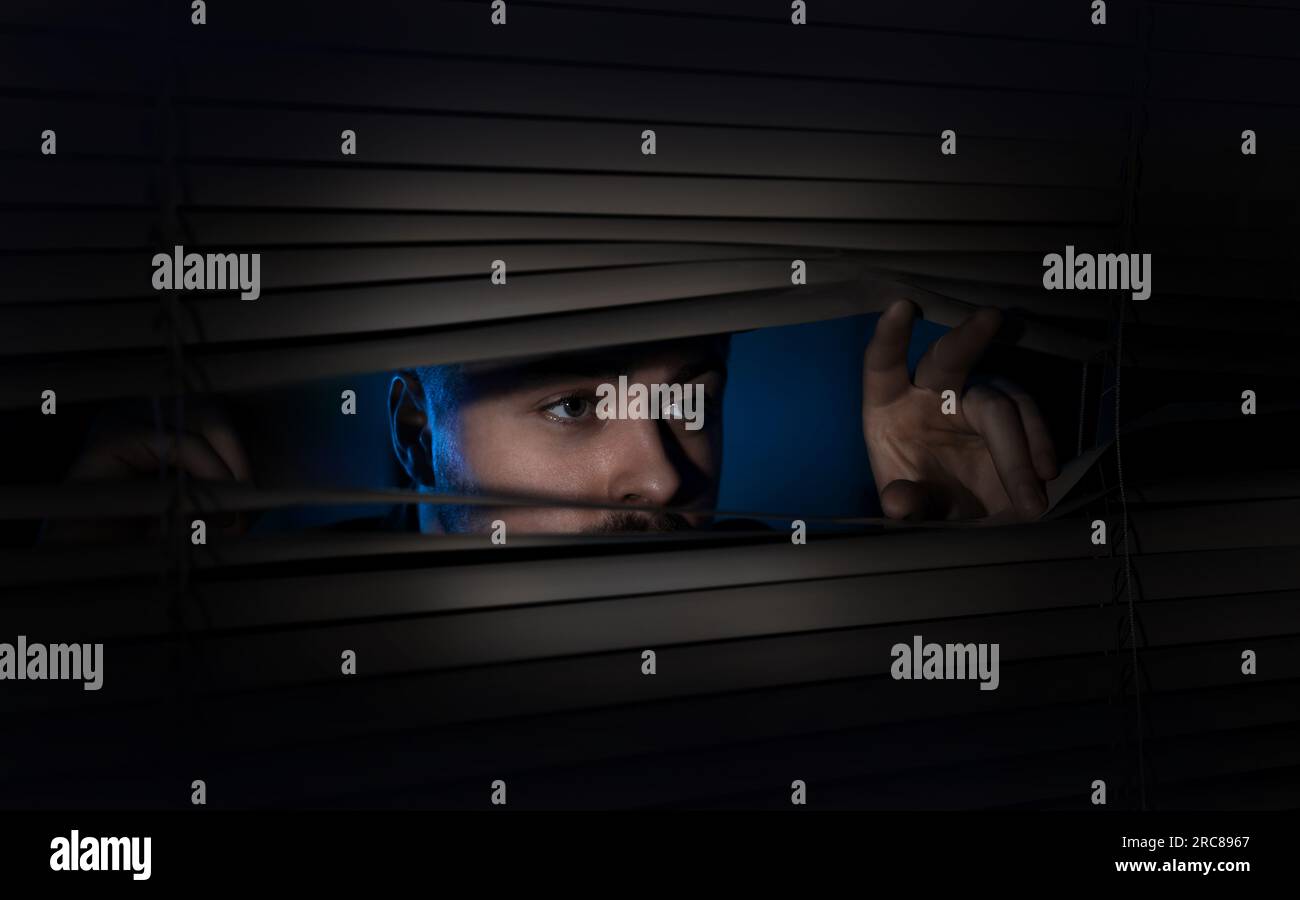 Man peeking window blinds hi-res stock photography and images - Alamy