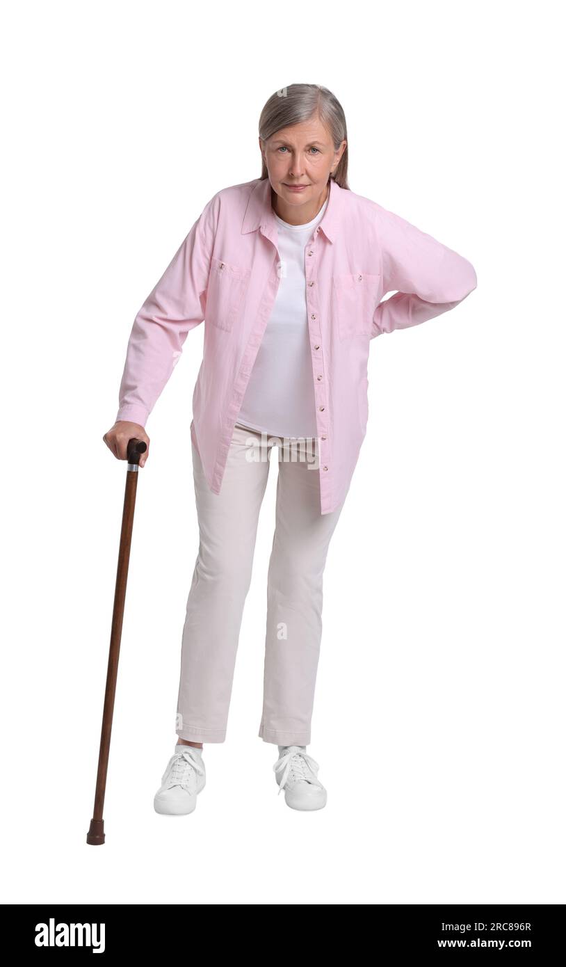 Senior woman with walking cane suffering from back pain on white ...