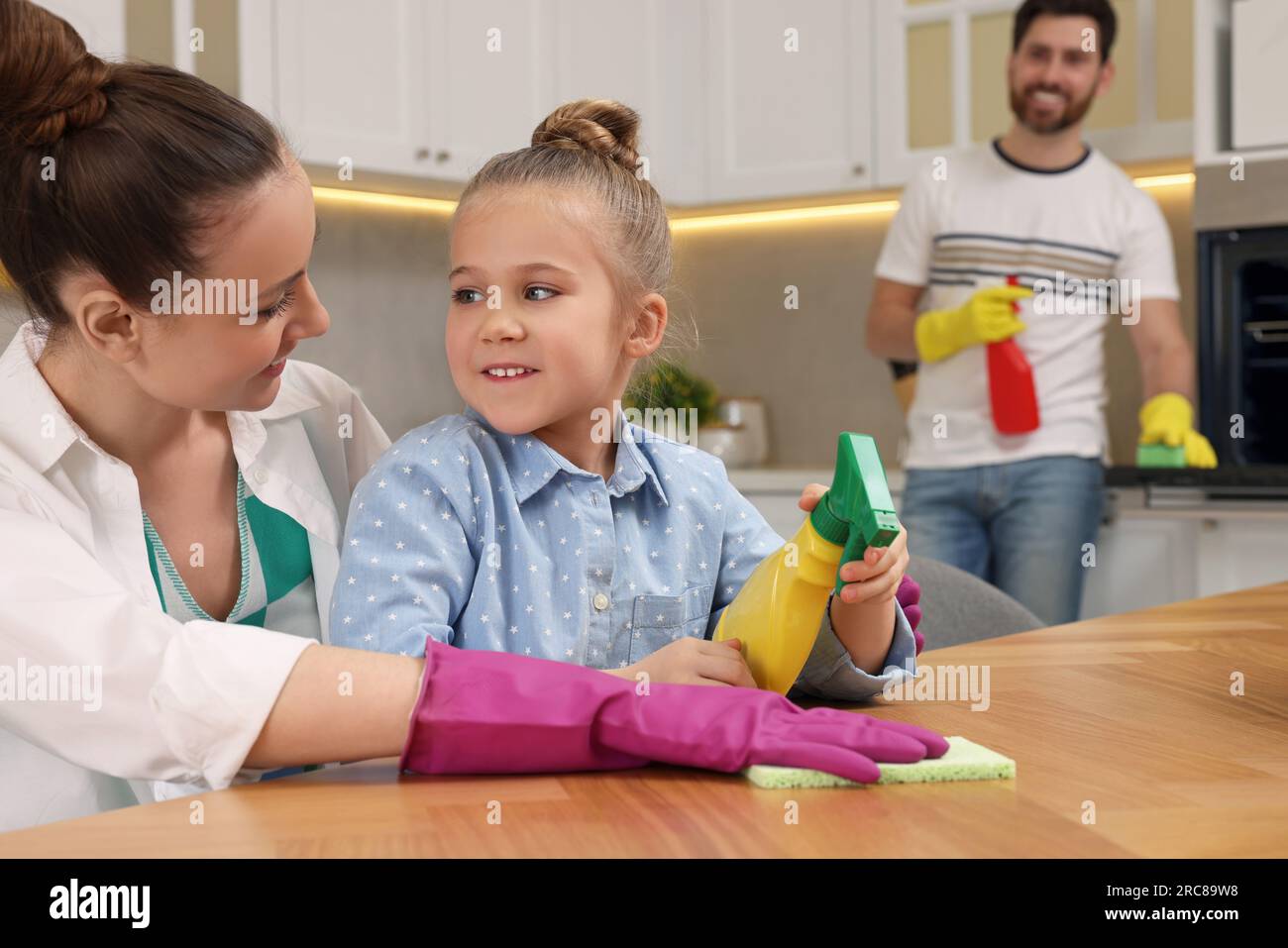 Spring cleaning. Happy family tidying up kitchen together Stock Photo ...