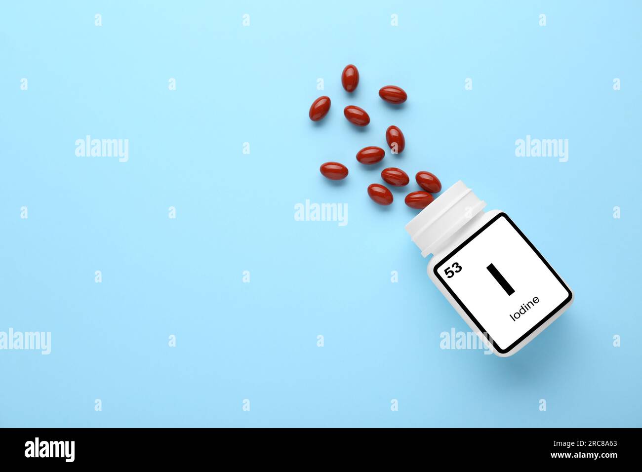 Plastic jar and iodine pills on light blue background, flat lay. Space ...
