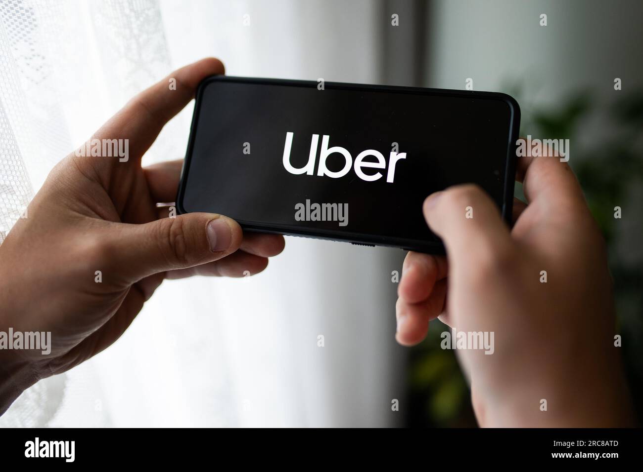 In this photo illustration a Uber logo seen displayed on a smartphone ...