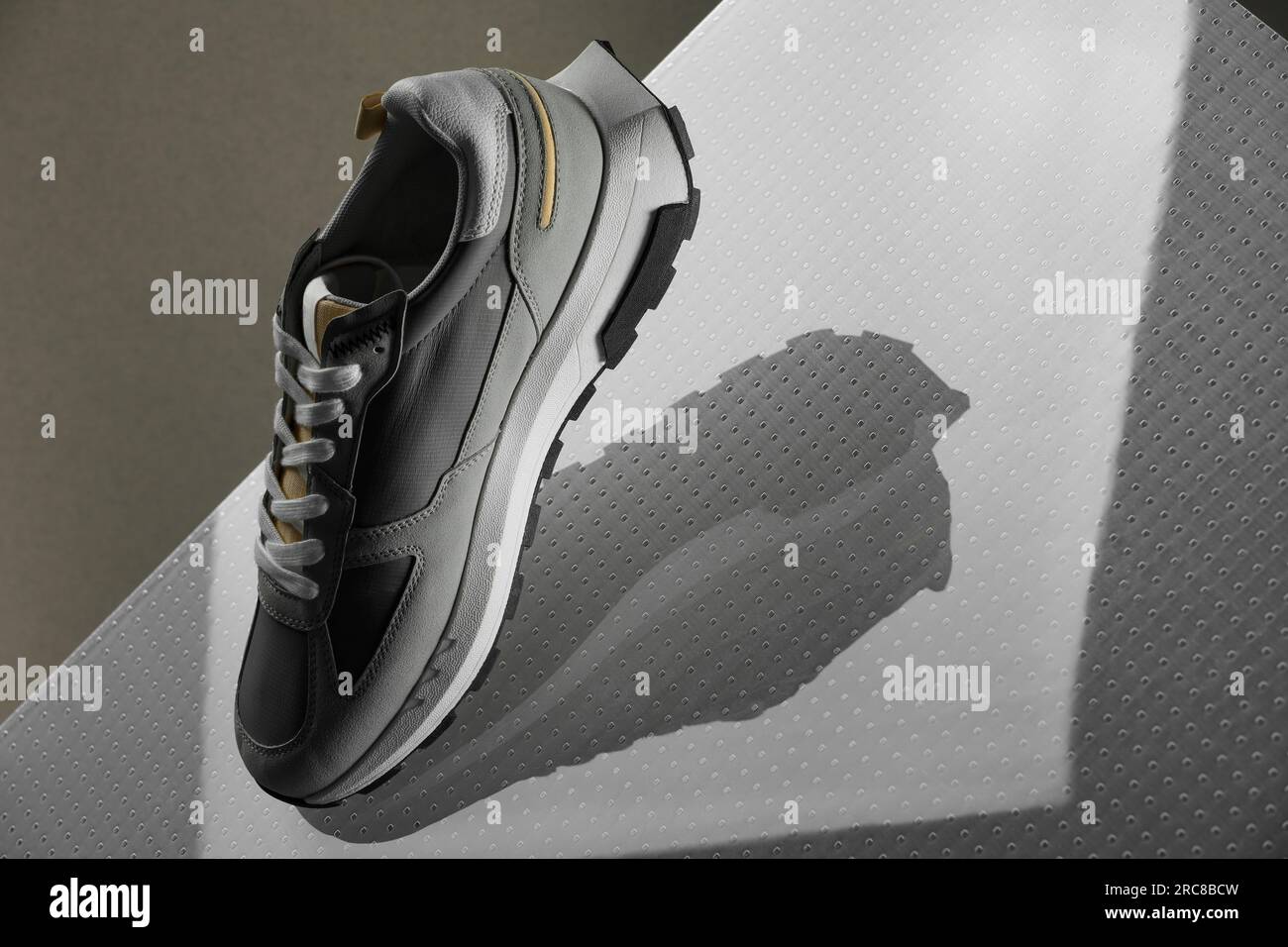 Stylish presentation of trendy sneaker against grey background Stock ...