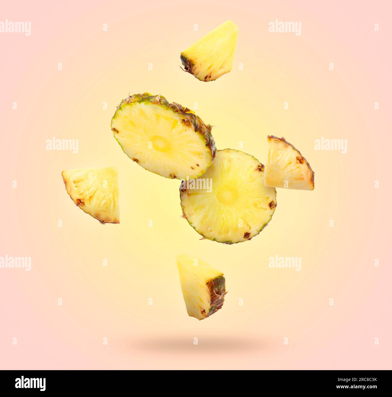 Fresh pineapple slices falling on colorful background Stock Photo - Alamy