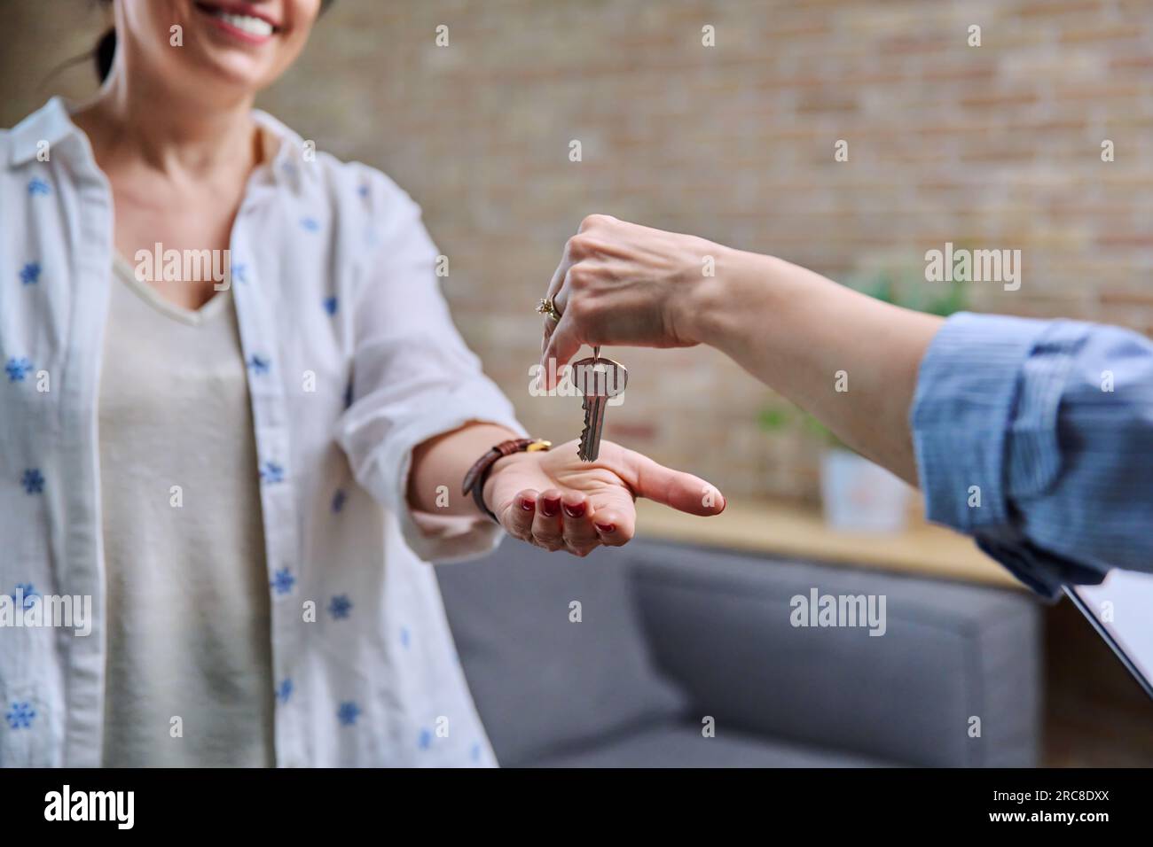 Mature woman buyer real estate tenant taking keys from realtor hands ...