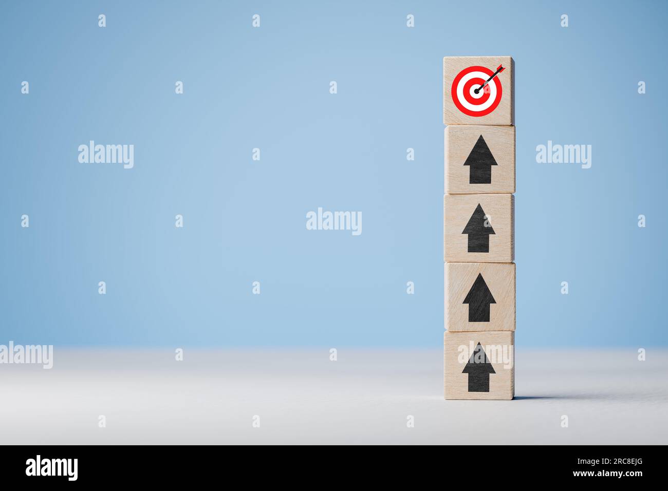 Arrow and target symbols on wooden blocks. Goal or agenda setting in ...