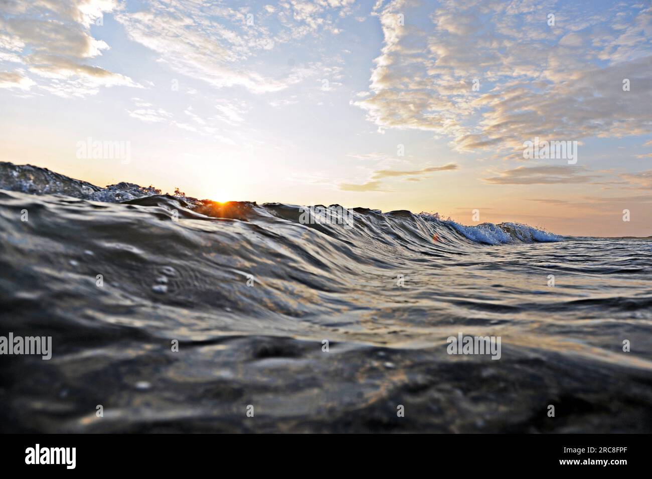 Blue waves splashing in sunset hi-res stock photography and images - Alamy