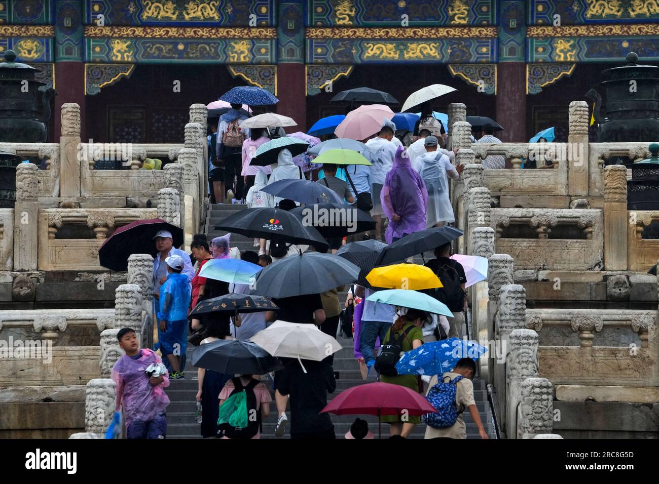 Visitors carrying umbrellas tour the Forbidden City on a rainy day in ...