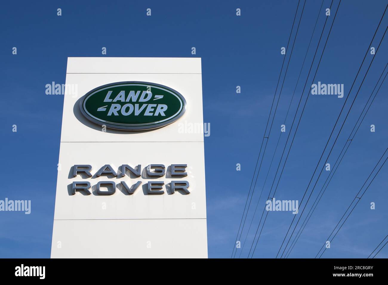 Land Rover car dealership sign against blue sky Stock Photo - Alamy