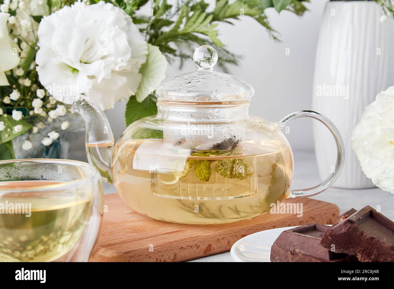 Aesthetic tea time, teapot, green tea and chocolate in biophilic ...