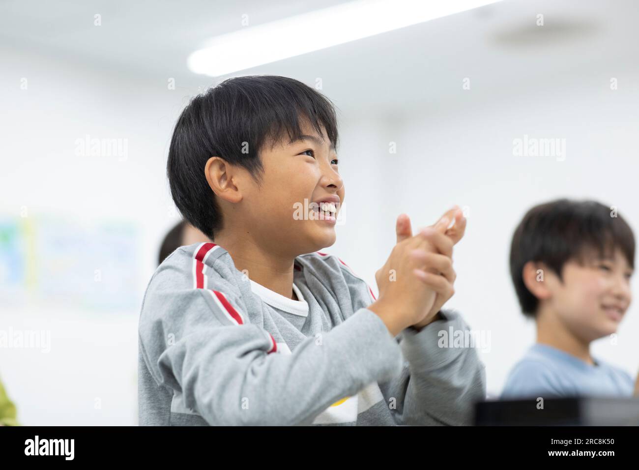 Smiling elementary school students taking a class Stock Photo - Alamy